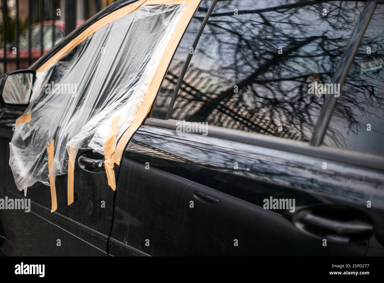a smashed side car window covered with cellophane and adhesive tape ...