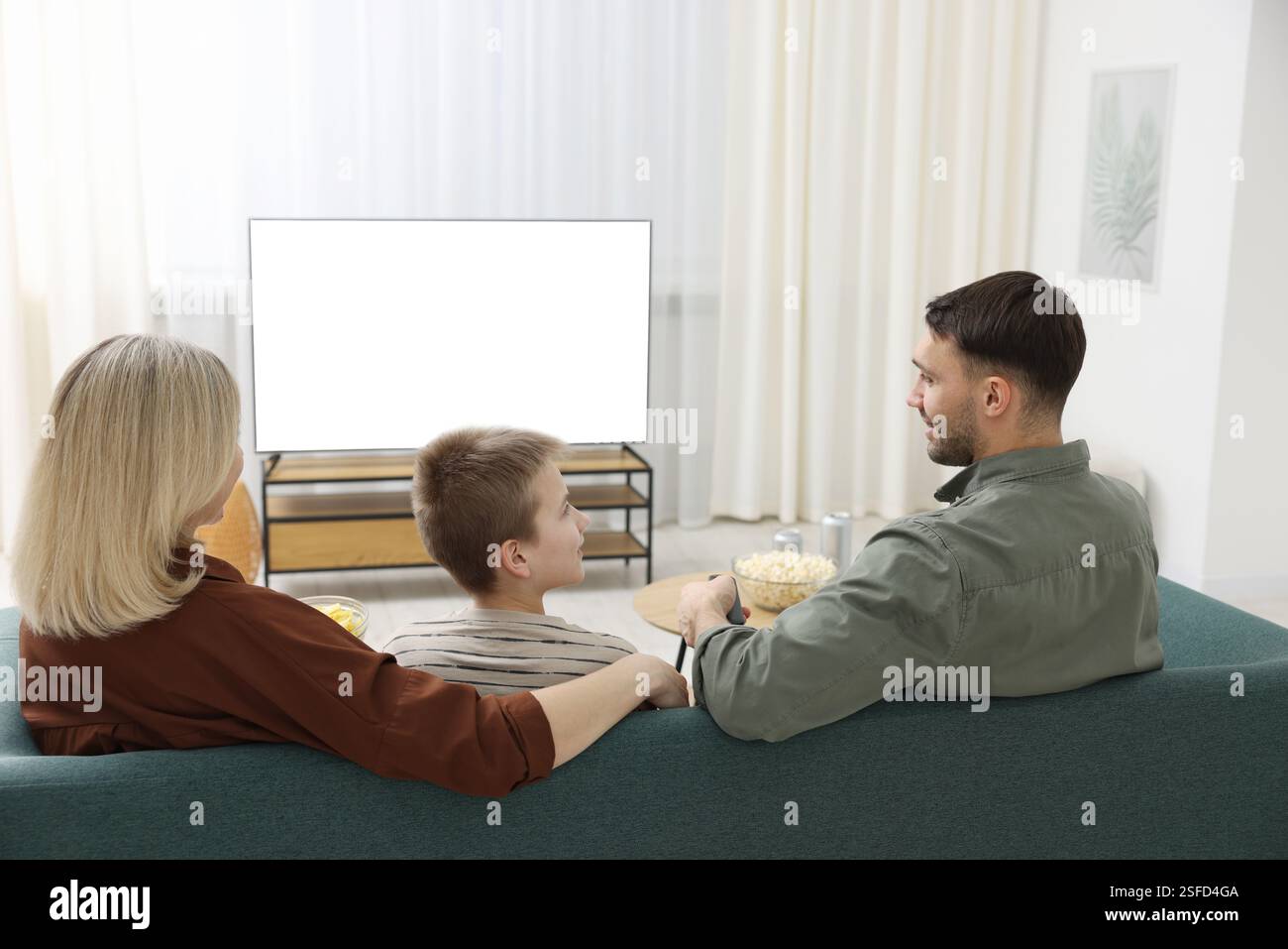 Happy family watching tv together at home, back view Stock Photo - Alamy