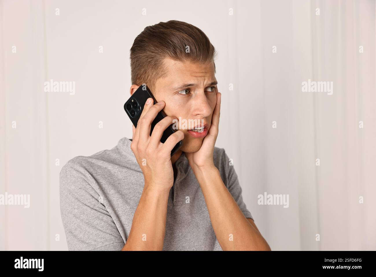 Stressed man calling hotline for mental health help indoors Stock Photo ...