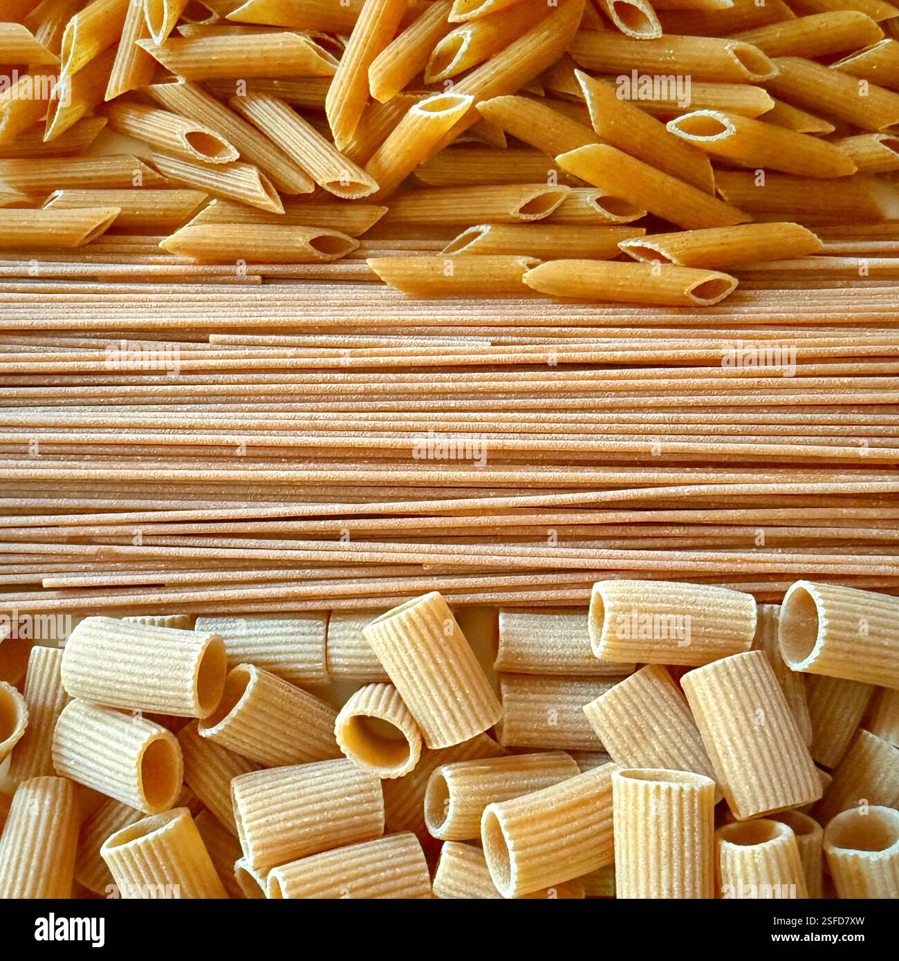 Close-up overhead view of assorted uncooked wholewheat spaghetti, penne ...