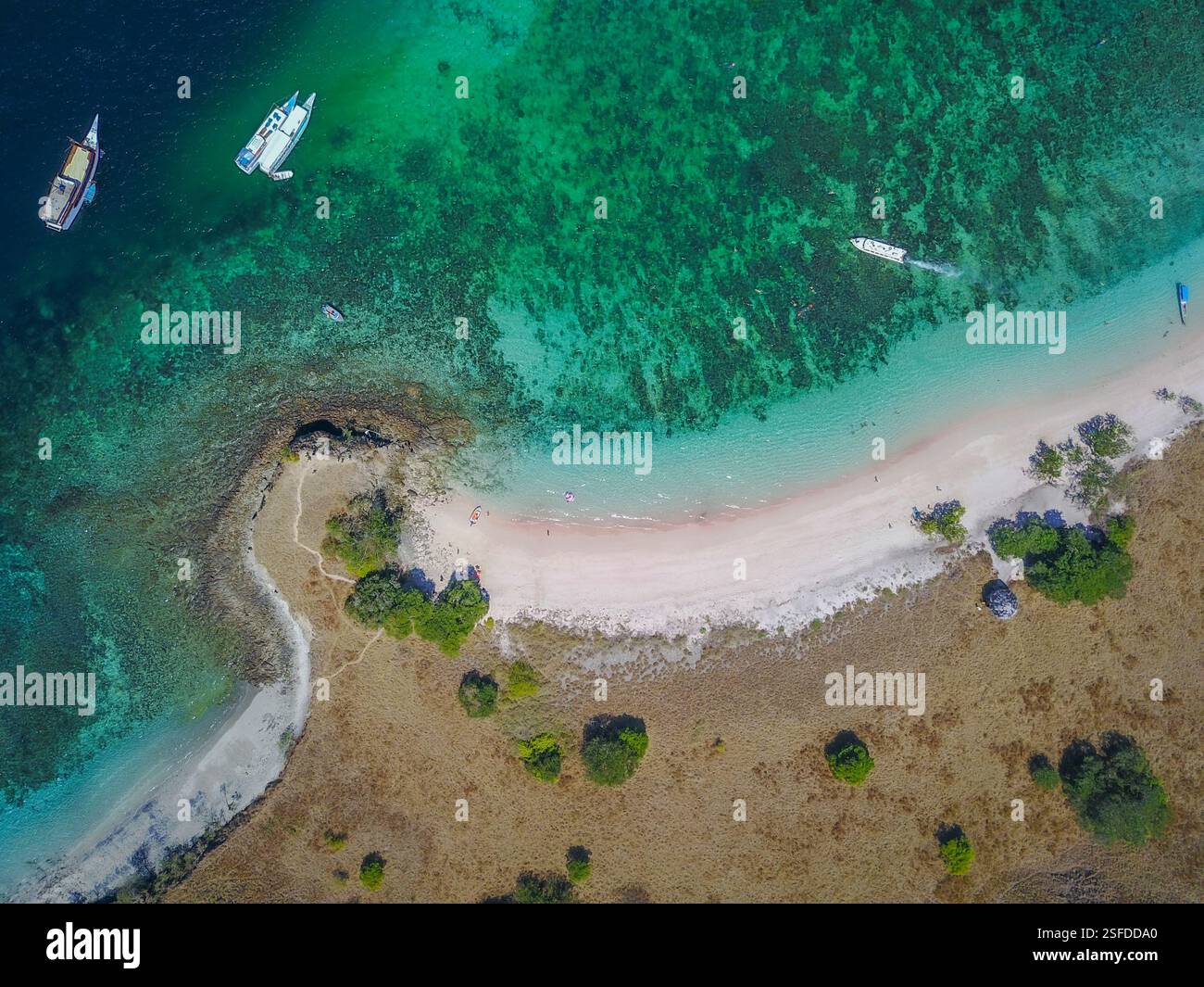 Aerial view of boats sailing by Pink Beach (Pantai Merah), Komodo ...