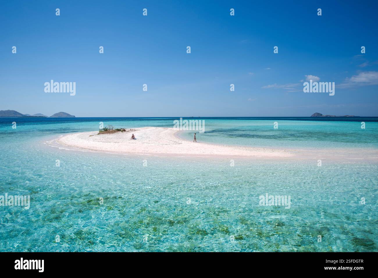 Two people on a sandbar island in the Indian Ocean, Taka Makassar ...