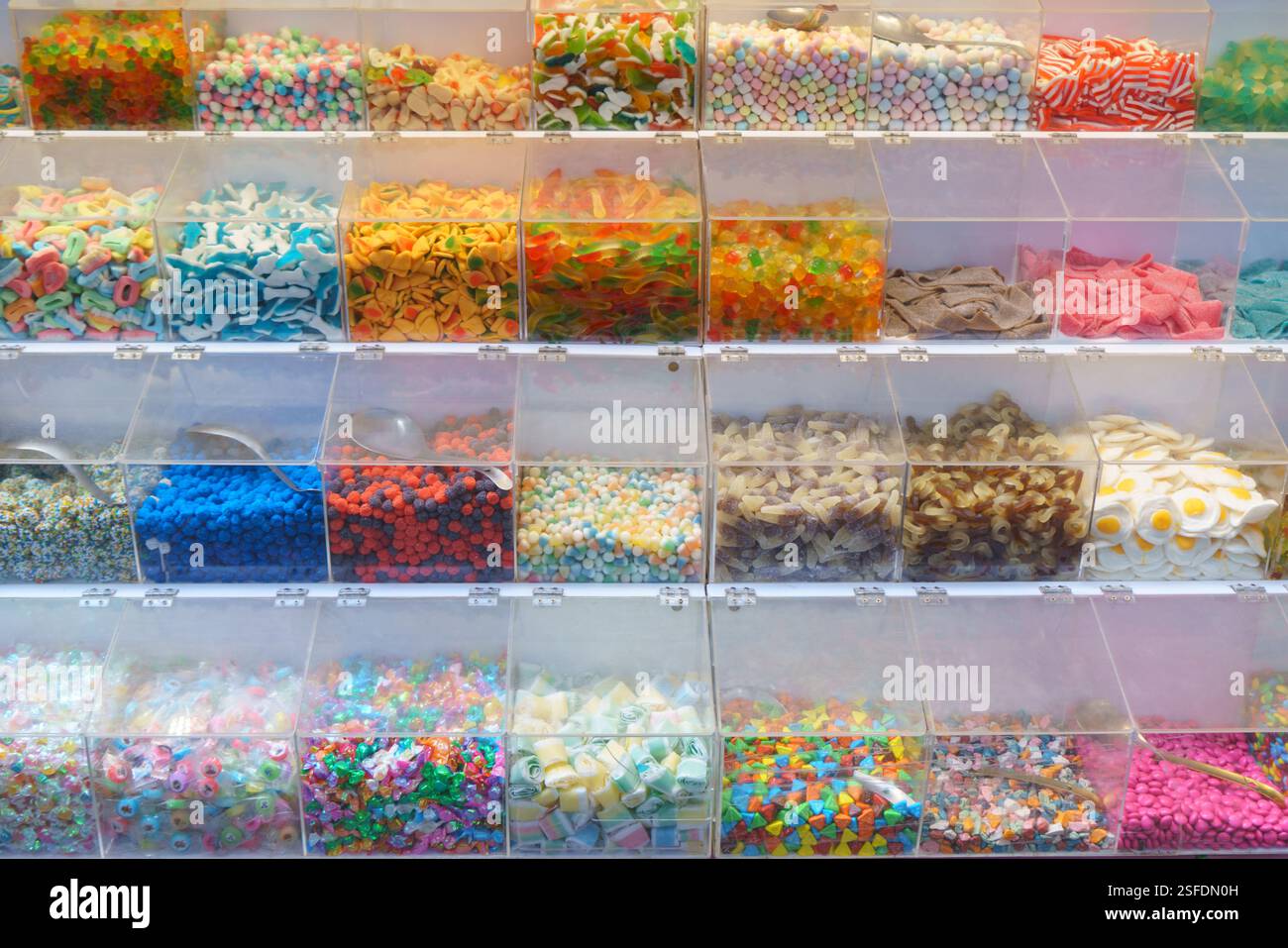 Rows of transparent bins filled with a variety of colorful candies ...