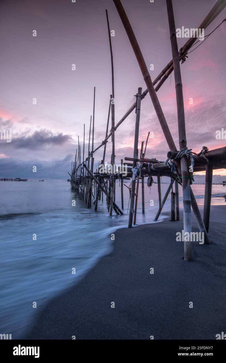 Receding water by a Bamboo pier on a beach at sunrise, Tanjung Kait ...