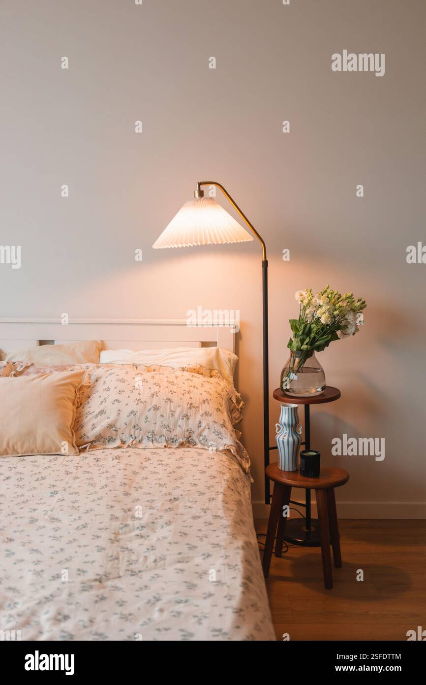 Bedroom interior with bedside tables and an illuminated lamp next to a ...