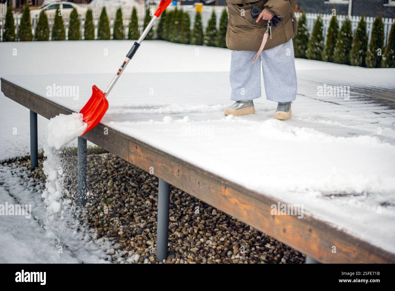 a woman removing snow from a patio with a shovel, street scenery Stock ...