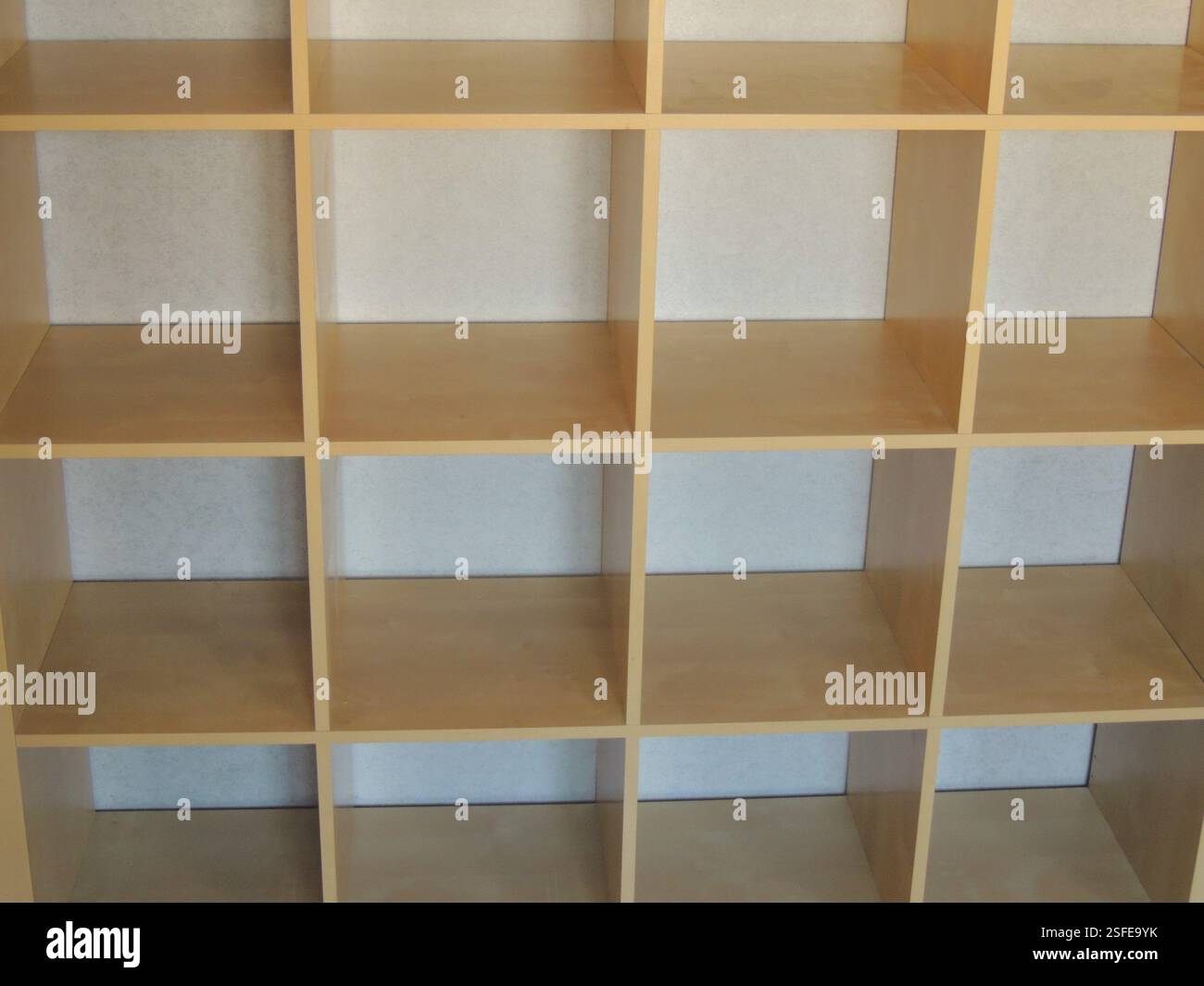 fragment of a bookcase with square empty cells made of light polished ...