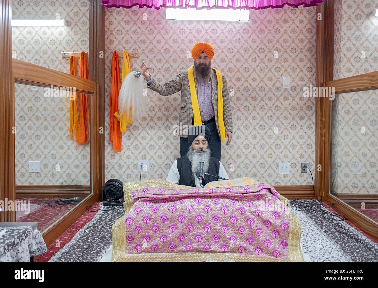 A Sikh waves his Chaur Sahib fly whisk at an Akhand Path service where ...