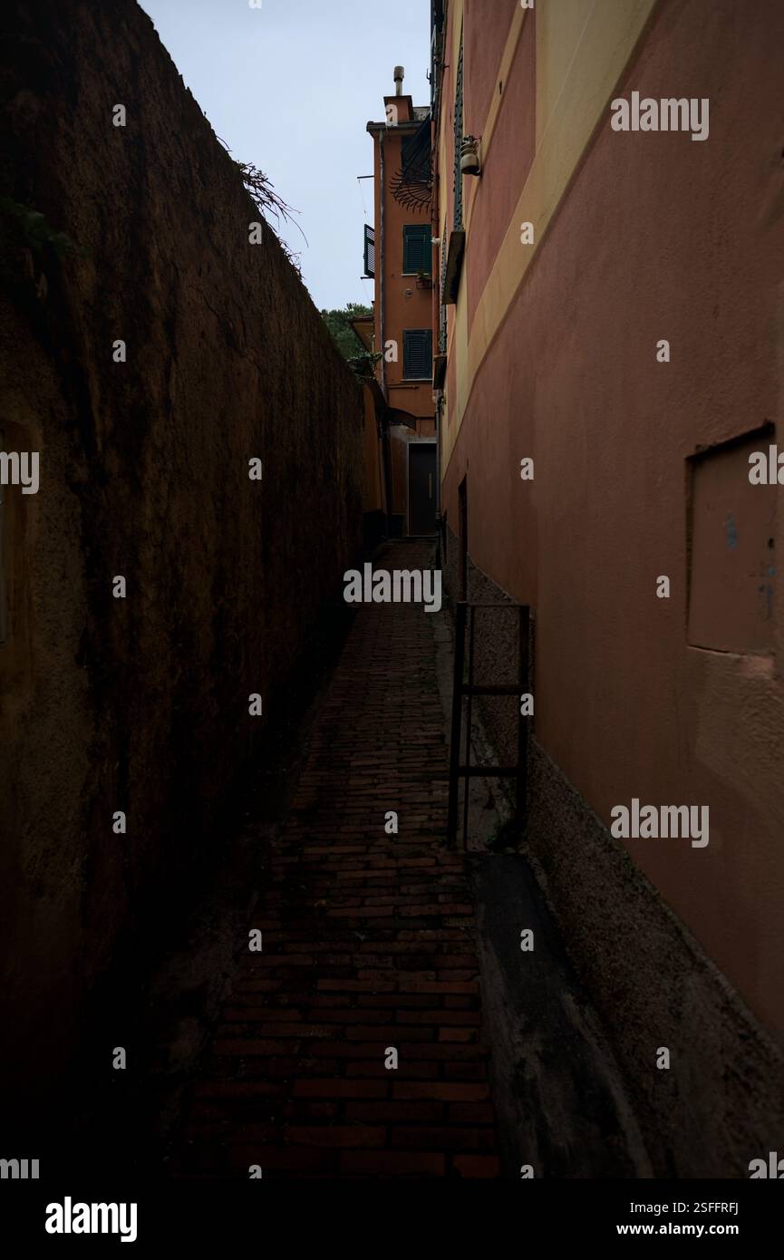 Very narrow alley between a wall and a building in a village Stock ...