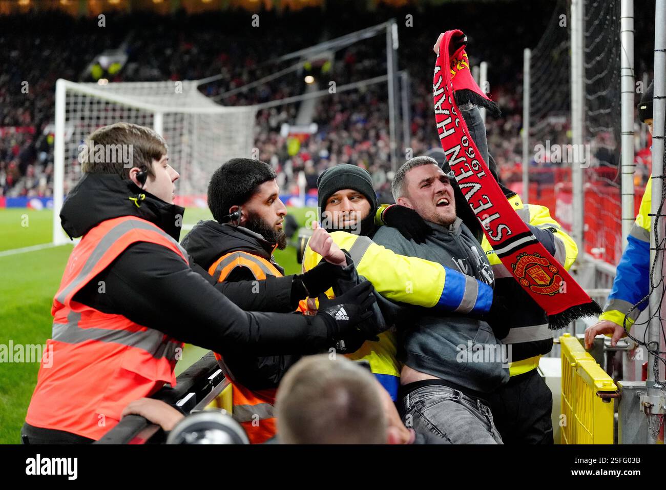Stadium staff prevent a supporter from invading the pitch during the ...