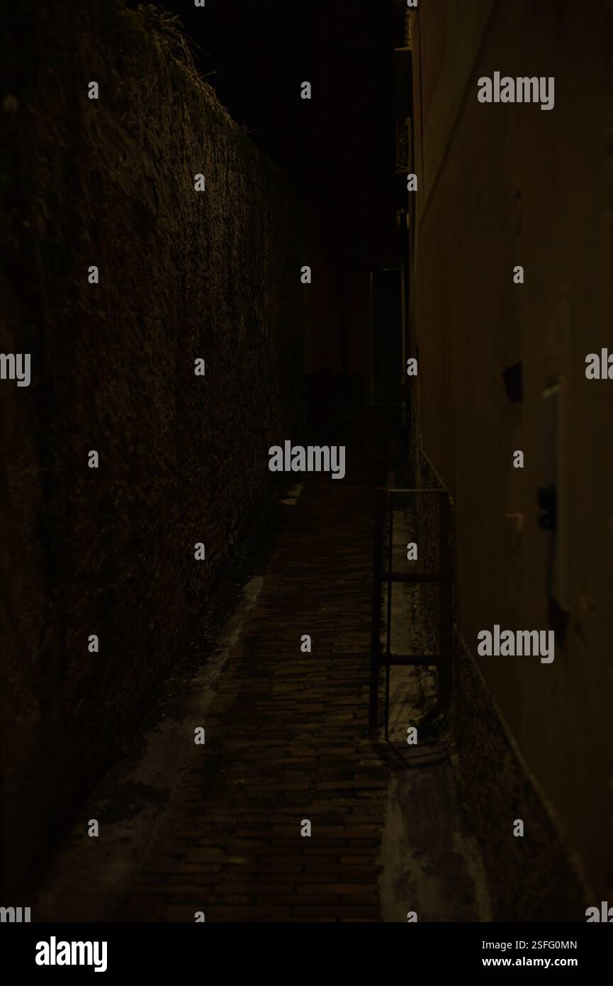 Very narrow alley between a wall and a building in a village Stock ...