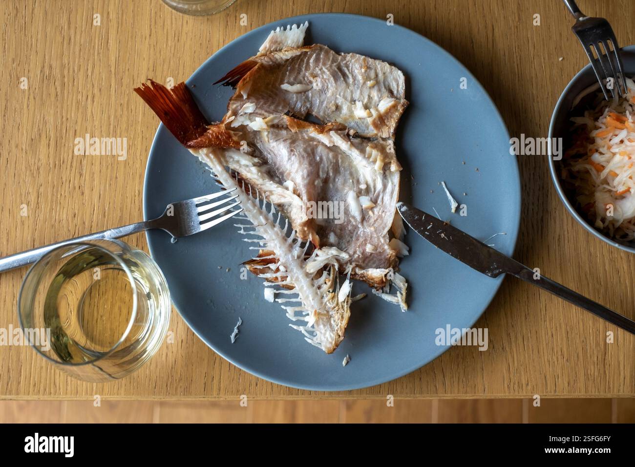 bones and skin of the eaten fish on a dining table, above view Stock ...