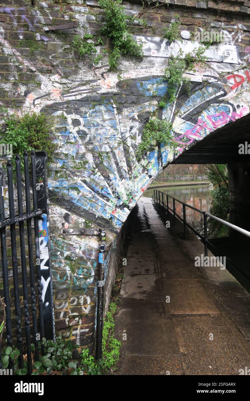Graffiti covered bridge and towpath along Regents Canal in London Stock ...