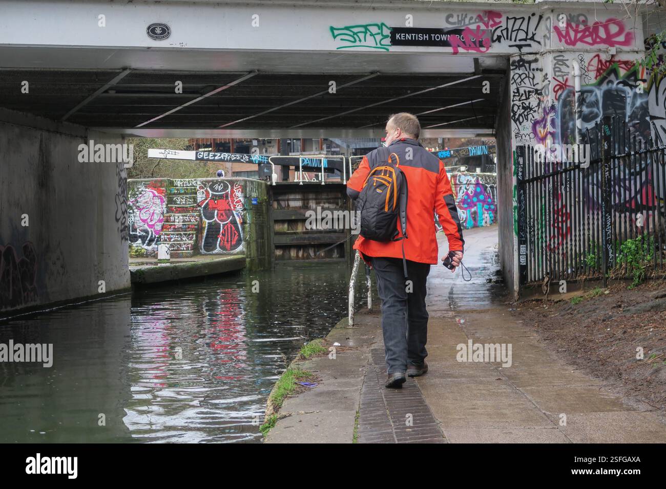 Man walking under a bridge over Regents Canal at Kentish Town, London ...