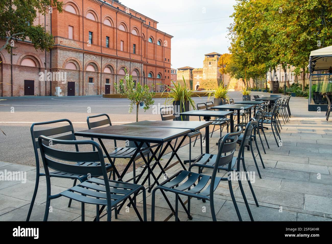 Outdoor cafe with tables and chairs on paved terrace in old town square ...