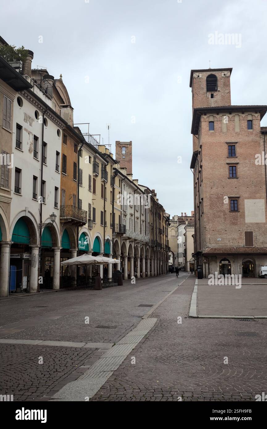 Cobblestone paved square under a historic building with a tower in an ...