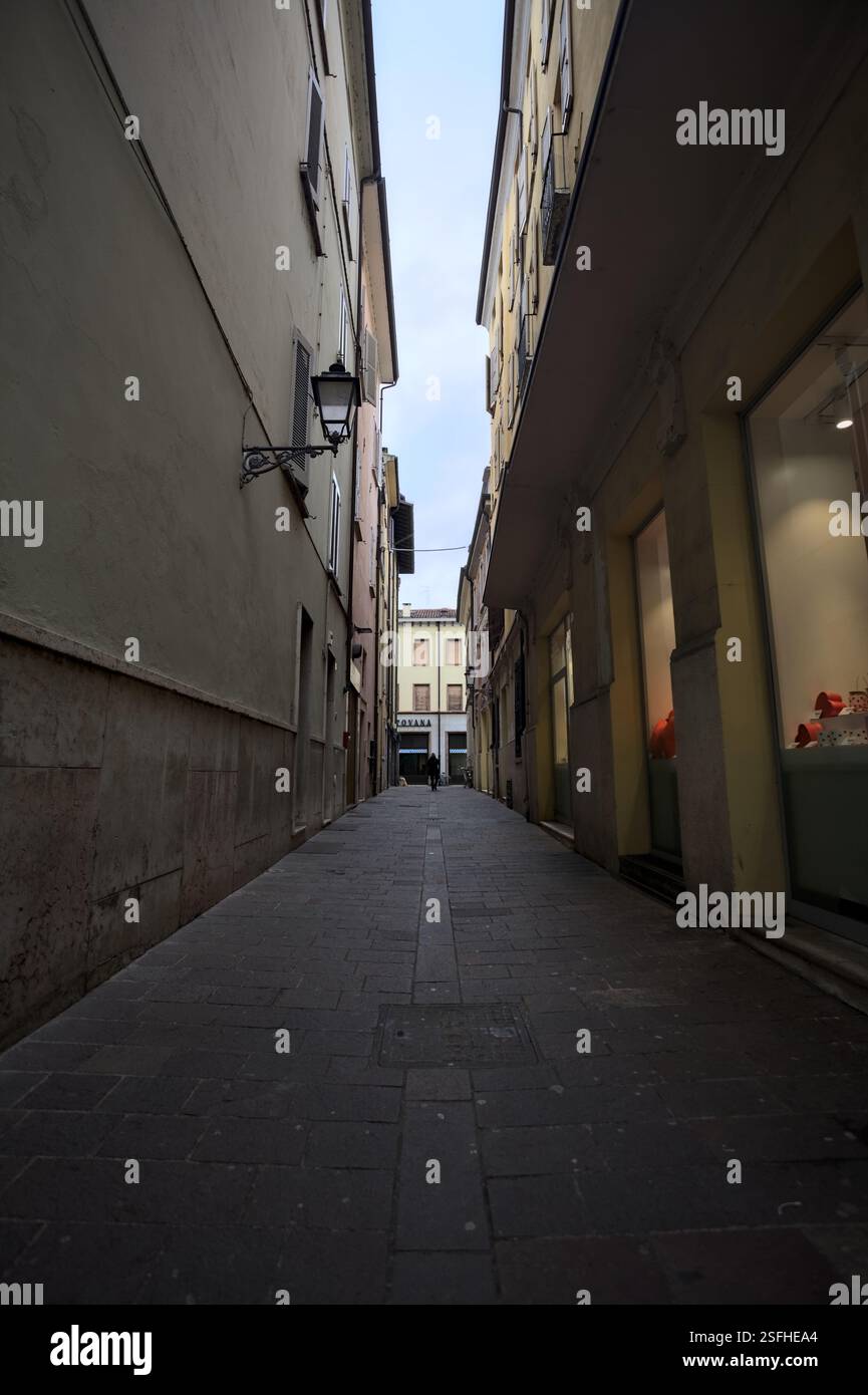 Paved alley with shop windows in the back of two buildings in an ...