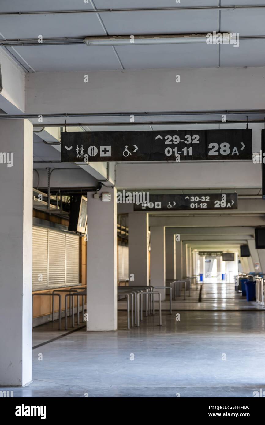 An open corridor in a public building features directional signs ...