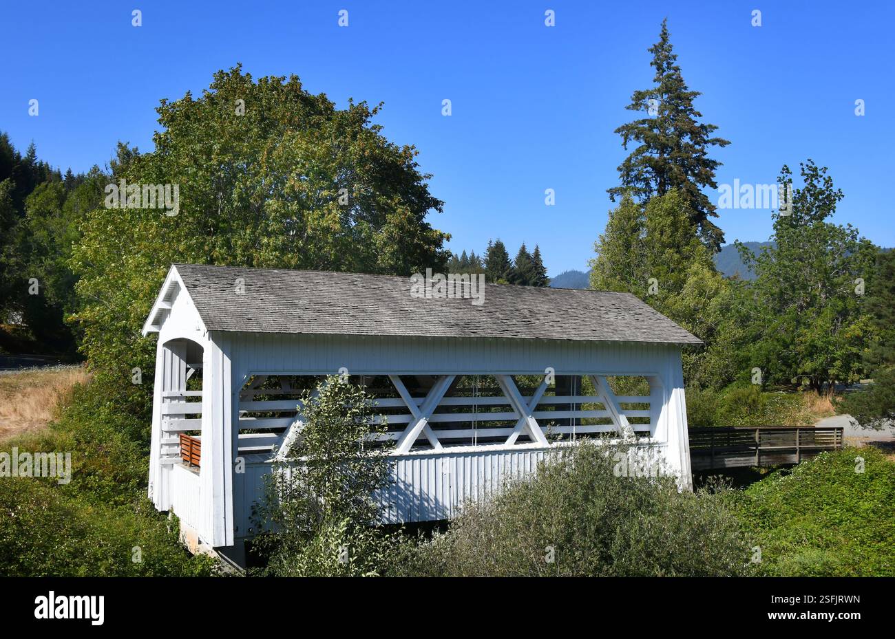 Sandy Creek Covered Bridge spans Sandy Creek in Oregon. It is a white ...