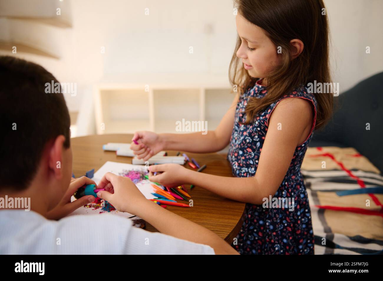 Two children playing with colorful pencils and craft materials at a ...