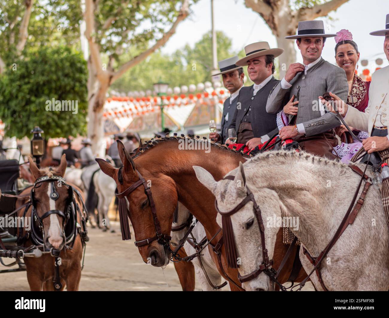 Group of Spanish riders in traditional attire on horseback at an ...