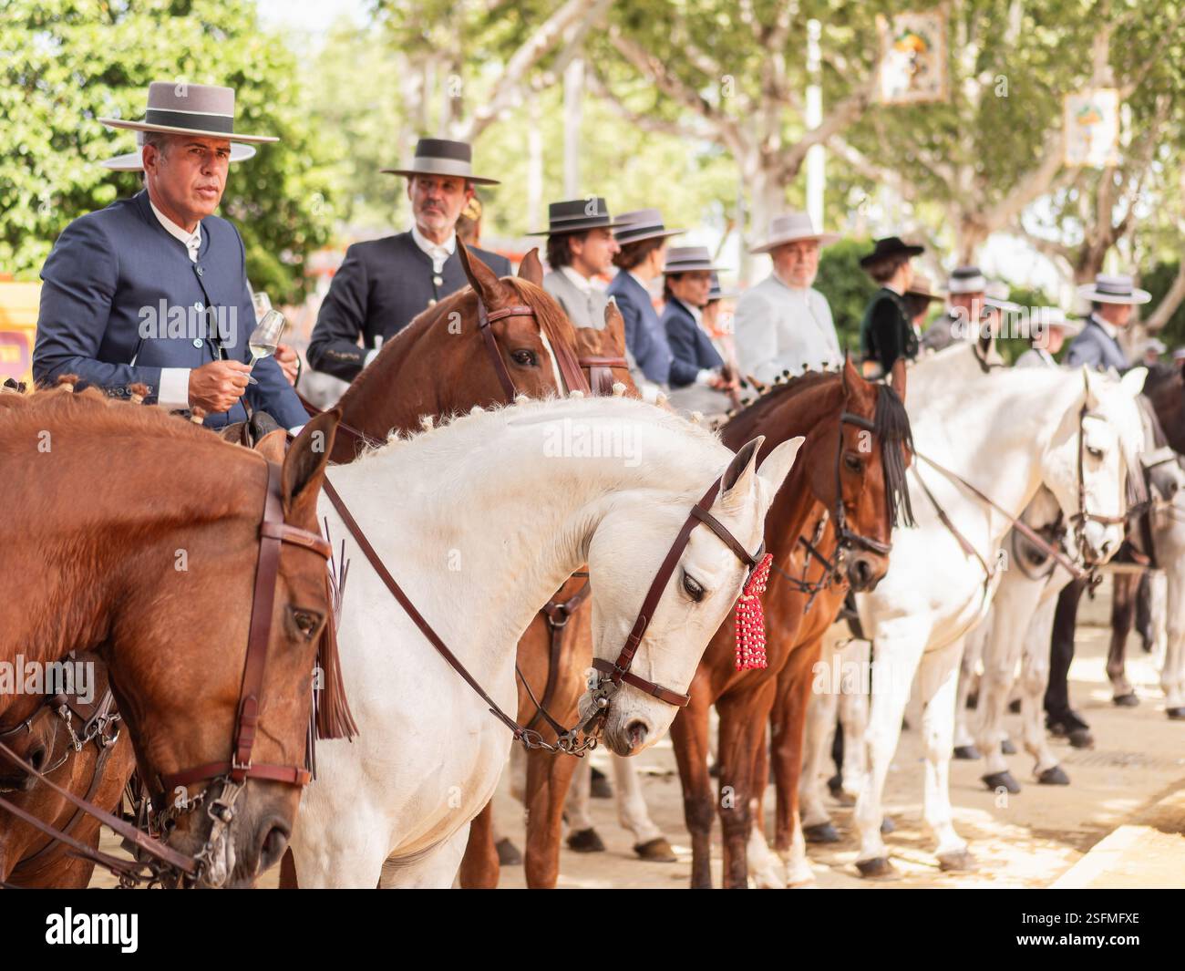 Group of Spanish riders in traditional attire on horseback at an ...