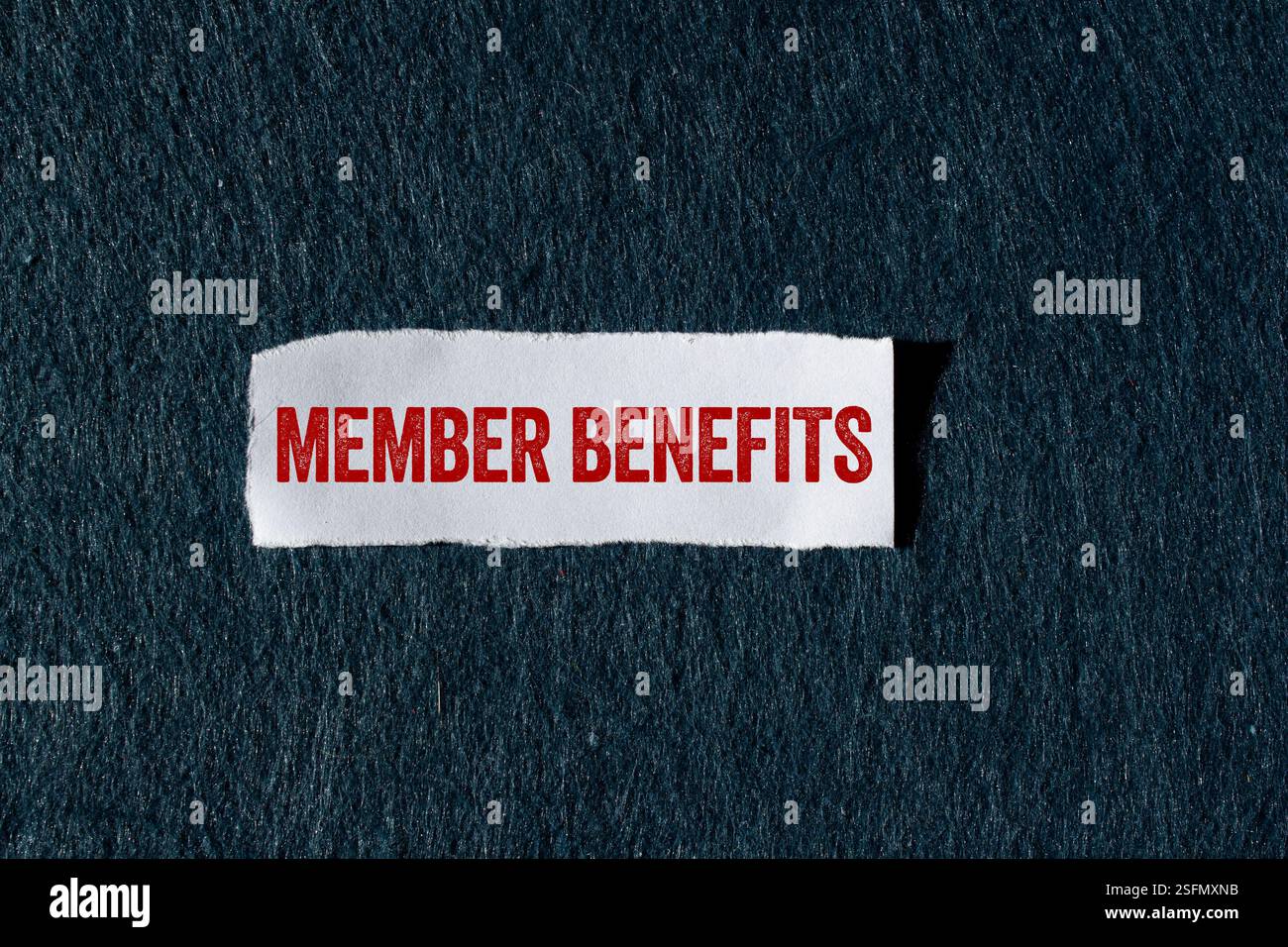 Member benefits message written on ripped torn paper piece with gray background. Conceptual ...