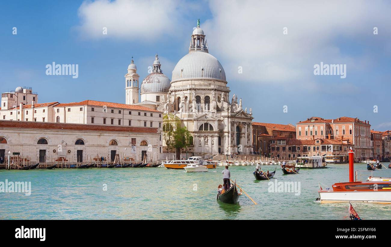 Tourism in Venice. Tourists on gondola cross the Grand Canal in front ...
