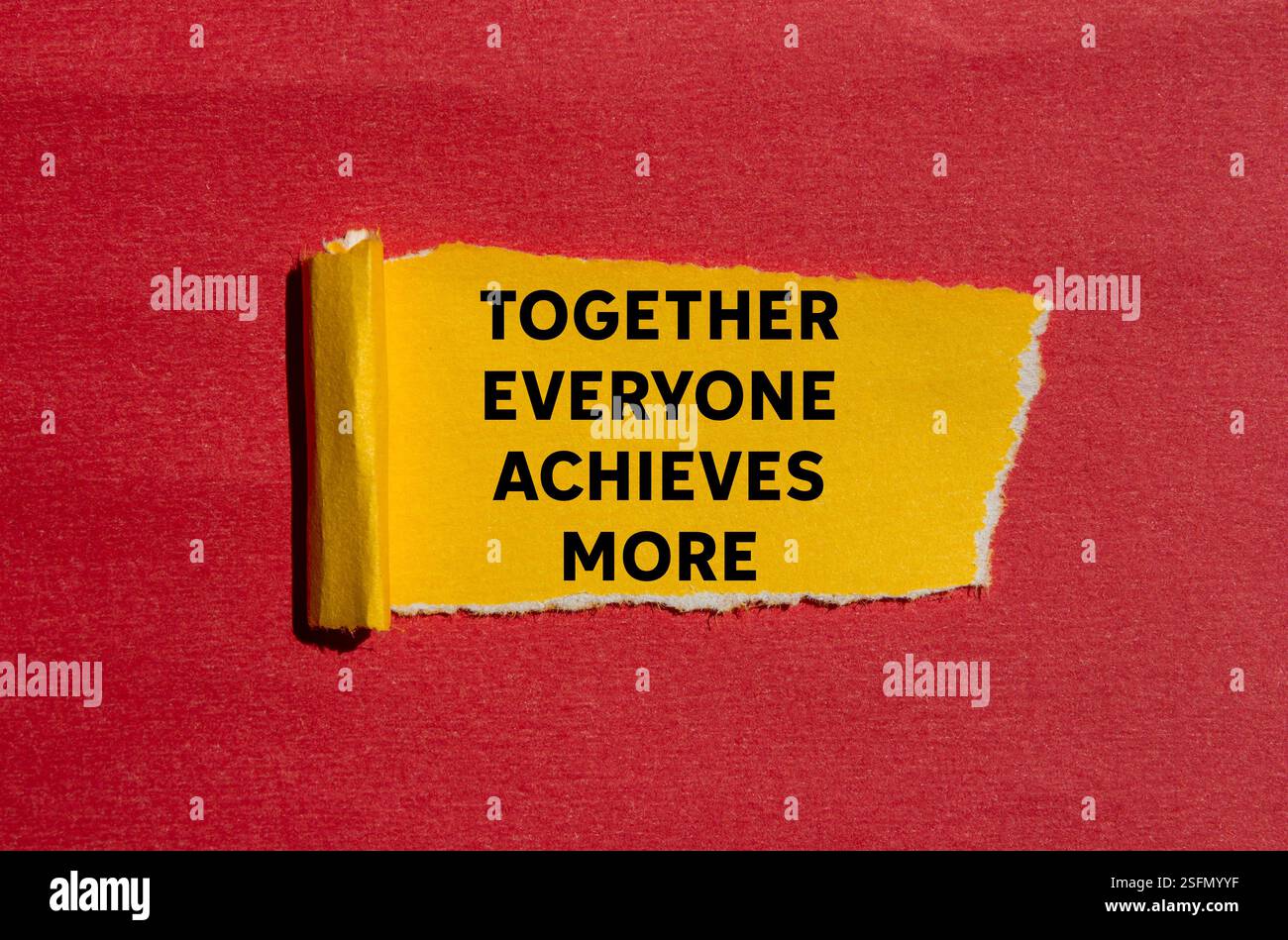 Together everyone achieves more message written on ripped torn yellow ...