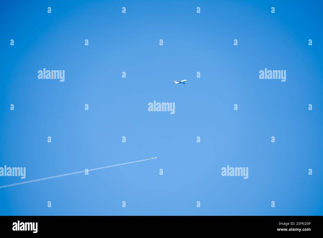 Airbus A380 and a twin engined jet liner aircraft in deep blue sky ...