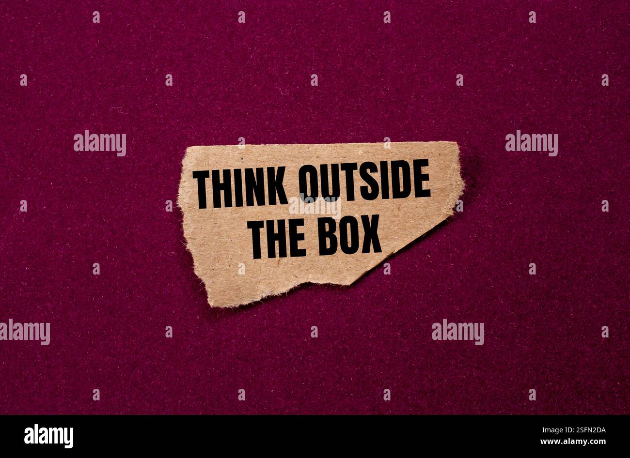 Think outside the box message written on ripped torn brown paper piece ...