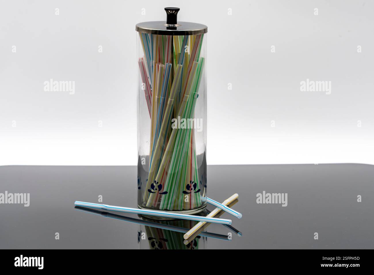 A transparent cylindrical container holds various colorful plastic ...