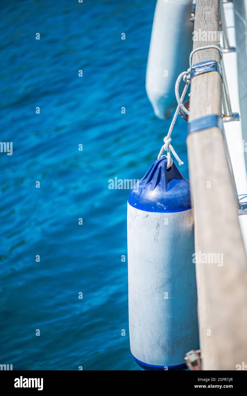 A close-up view of a fender hanging from a ship, secured with a sturdy ...