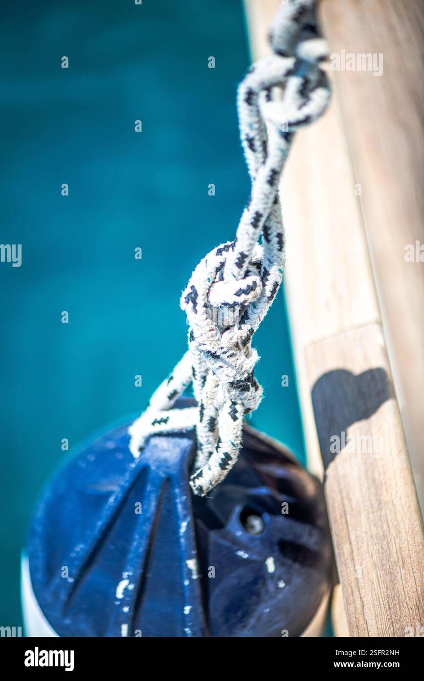 A close-up view of a fender hanging from a ship, secured with a sturdy ...