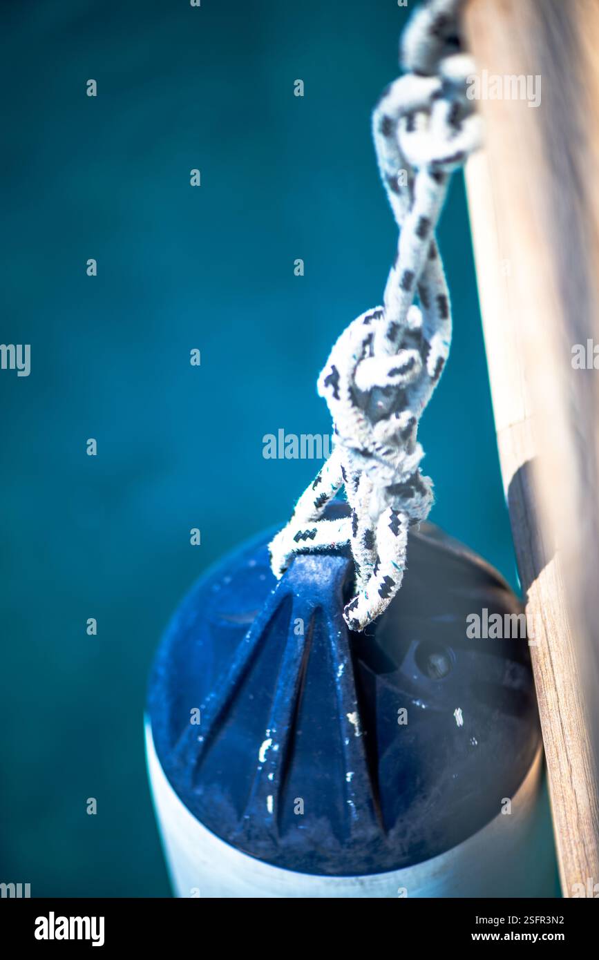 A close-up view of a fender hanging from a ship, secured with a sturdy ...