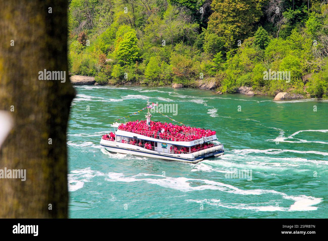 A packed boat navigates through vibrant turquoise waters Stock Photo ...