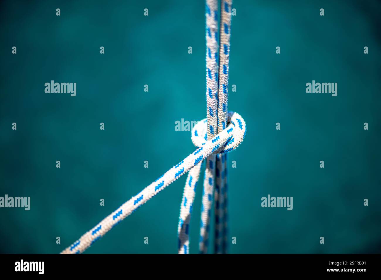 A close-up view of a securely tied rope and knot on a ship mast ...