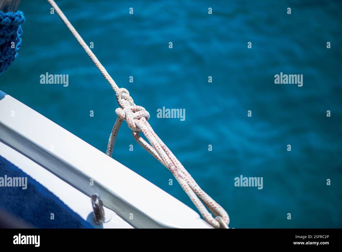 A close-up view of a securely tied rope and knot on a ship mast ...
