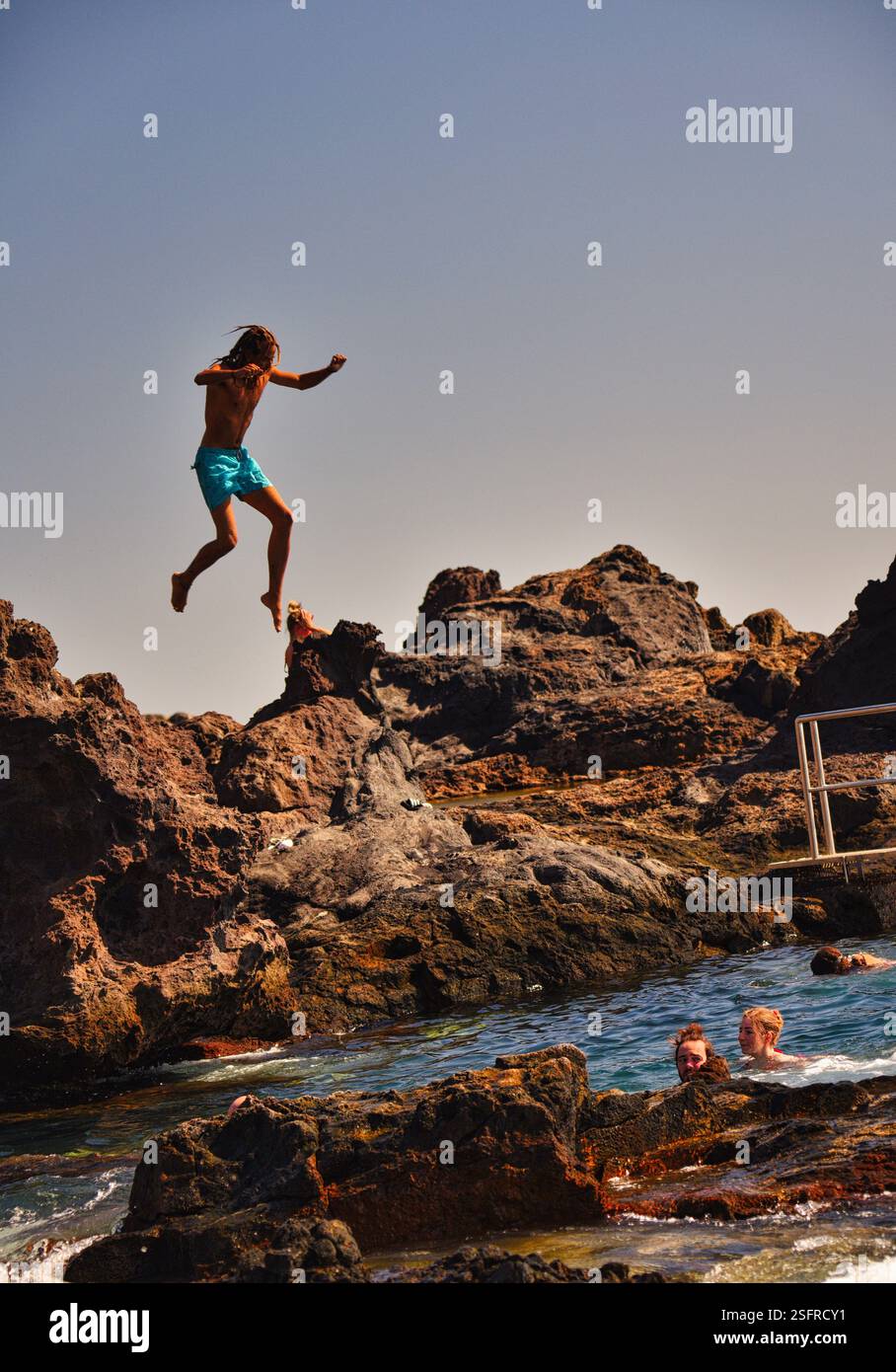 Man jumping from high rocks into pool Piscinas Naturales Los Abrigos ...
