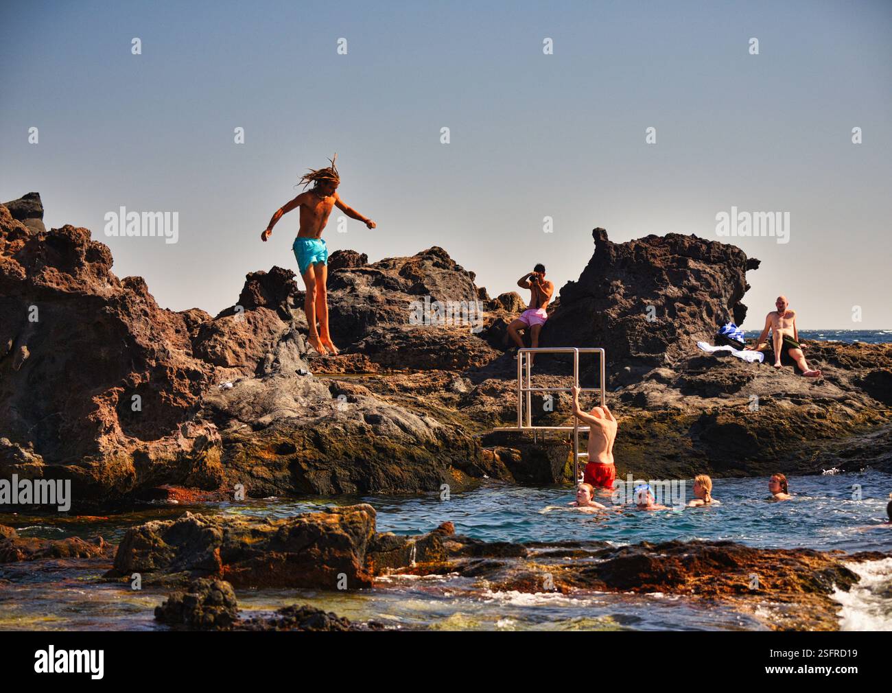 Man jumping from high rocks into pool Piscinas Naturales Los Abrigos ...
