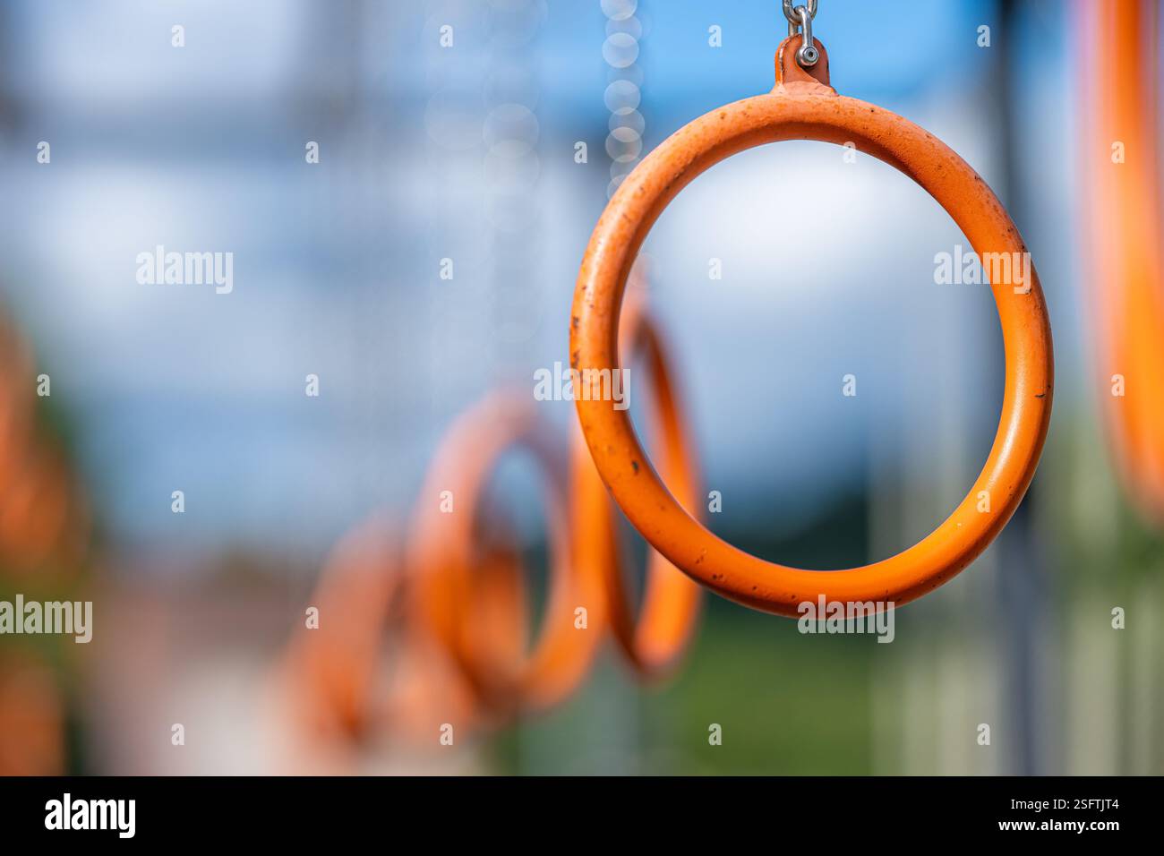 orange gymnastic rings hanging in a row in outdoor playground Stock ...