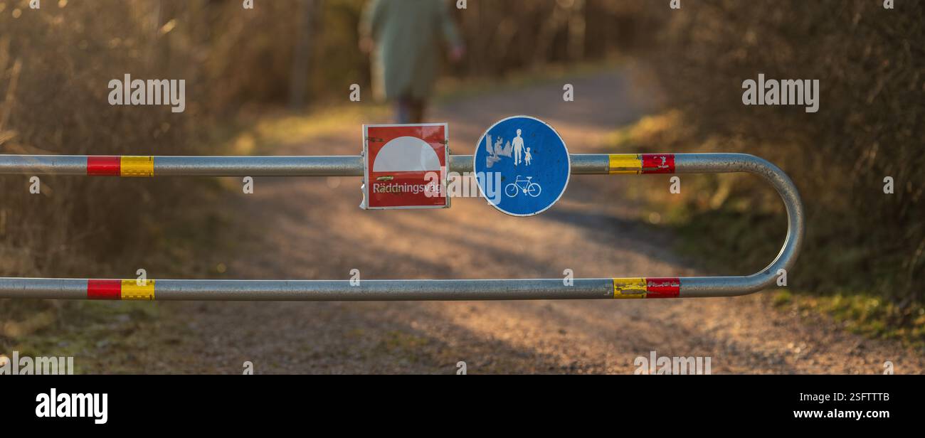barrier gate with signs on dirt path Stock Photo - Alamy