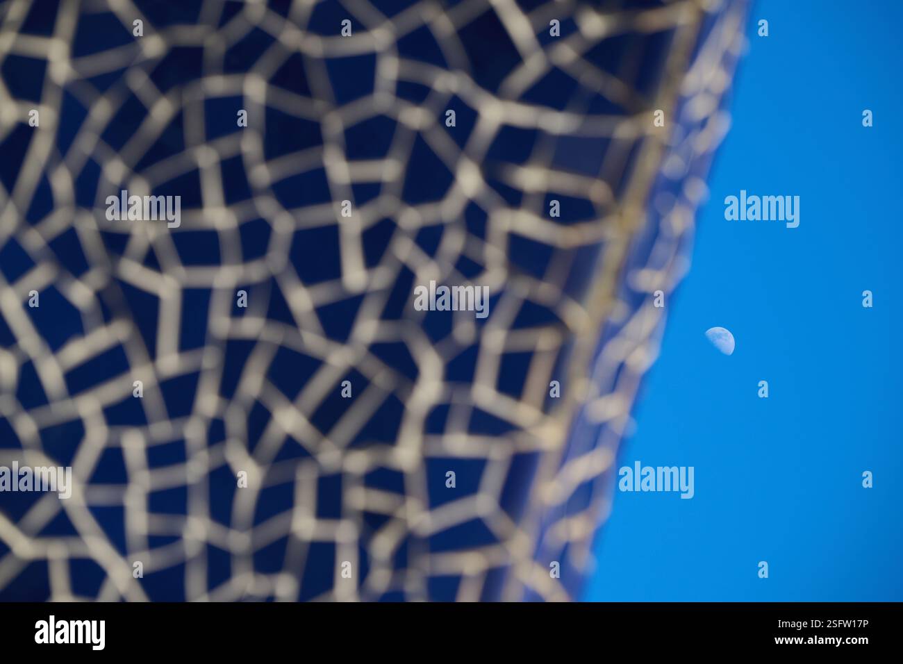 The moon is seen with a detail of a building at the City of Arts and ...
