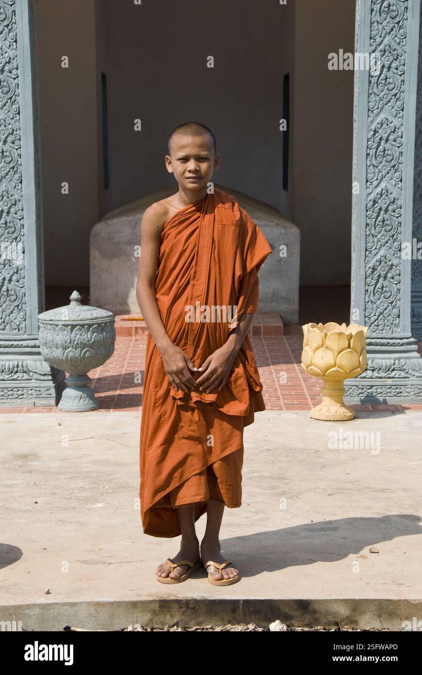 A young monk stands by Ta Mok's grave at a Buddhist temple in Anlong ...