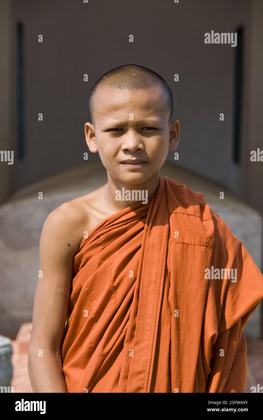 A young monk stands by Ta Mok's grave at a Buddhist temple in Anlong ...
