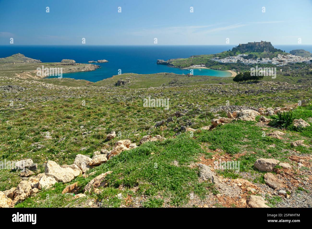 Green field in foreground and Lindos village at the background, in ...