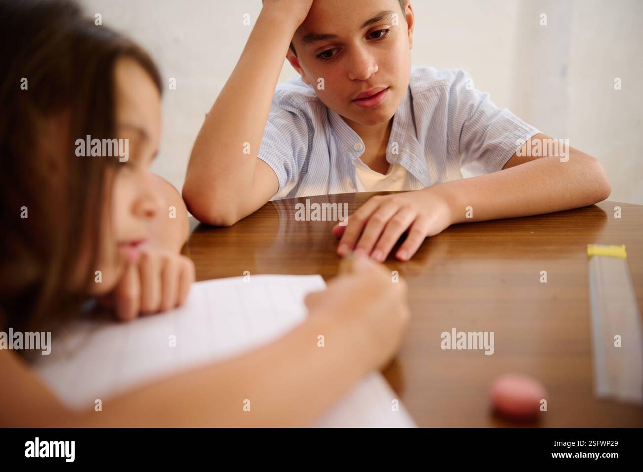 Two children working together on a school project at home, showing ...