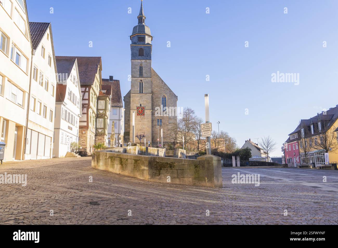 Old town scene with cobblestones and a church, illuminated by the sun ...