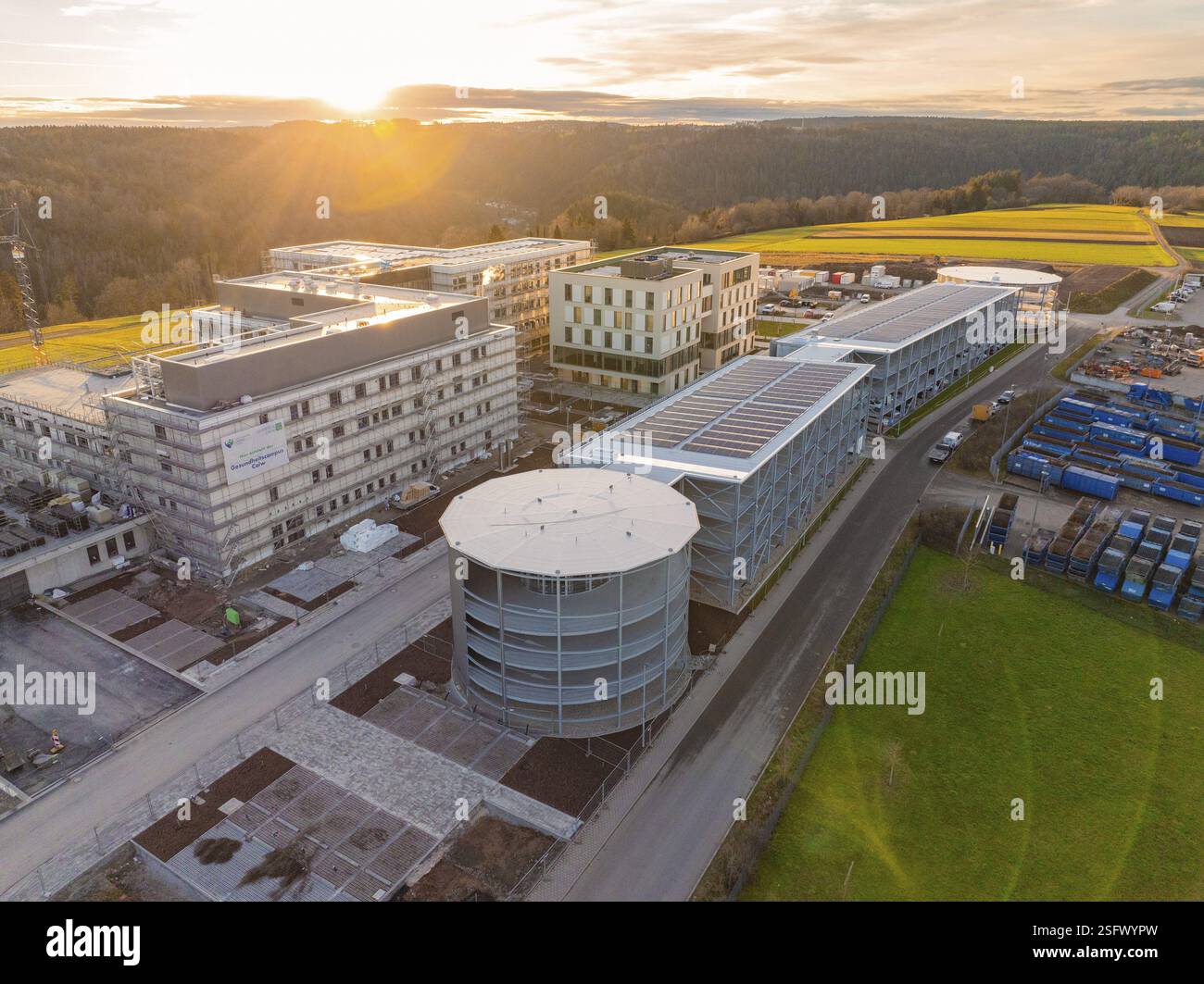 Construction site and modern buildings with sunset over the fields, new ...