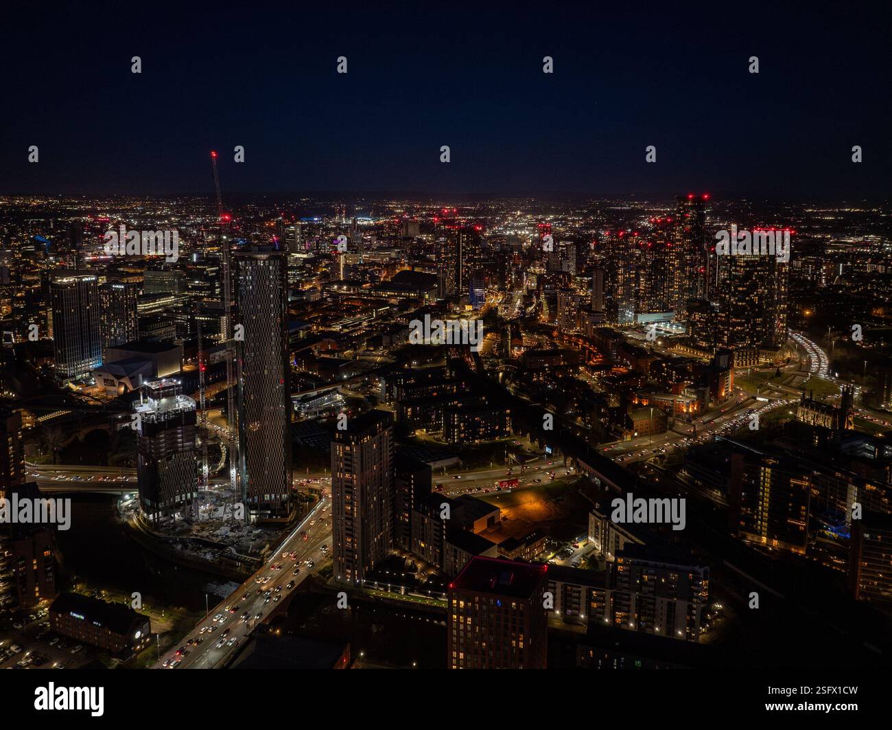 A vibrant and bustling night view of Manchester city depicting bright ...